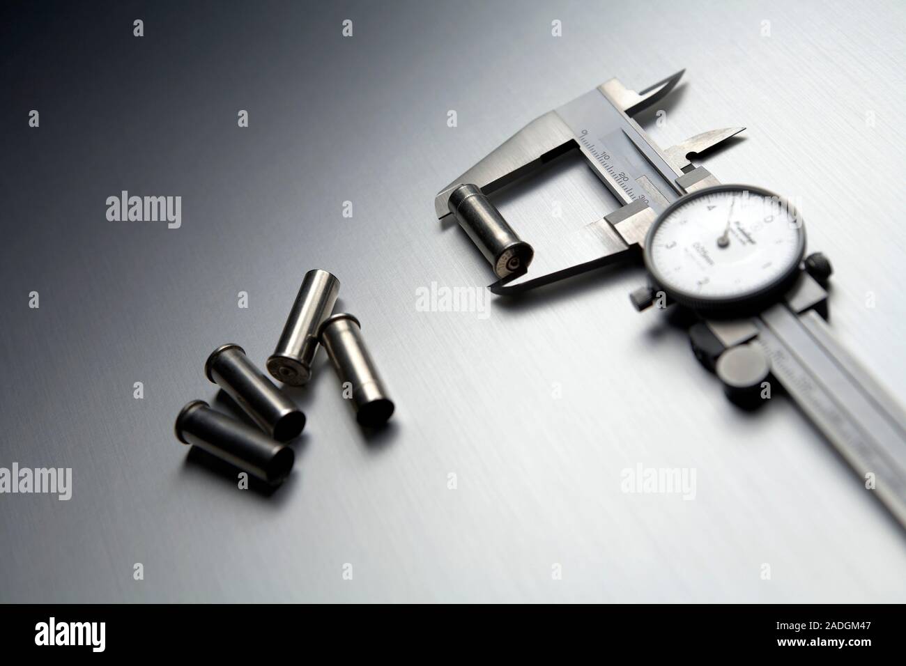 Bullet cases and calipers. Dial calipers being used to accurately ...