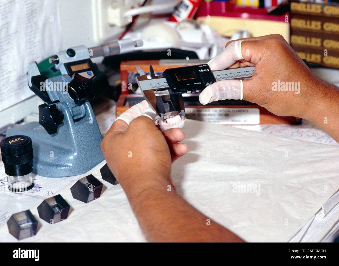 Precision measurement. A technician using a pair of digital calipers ...