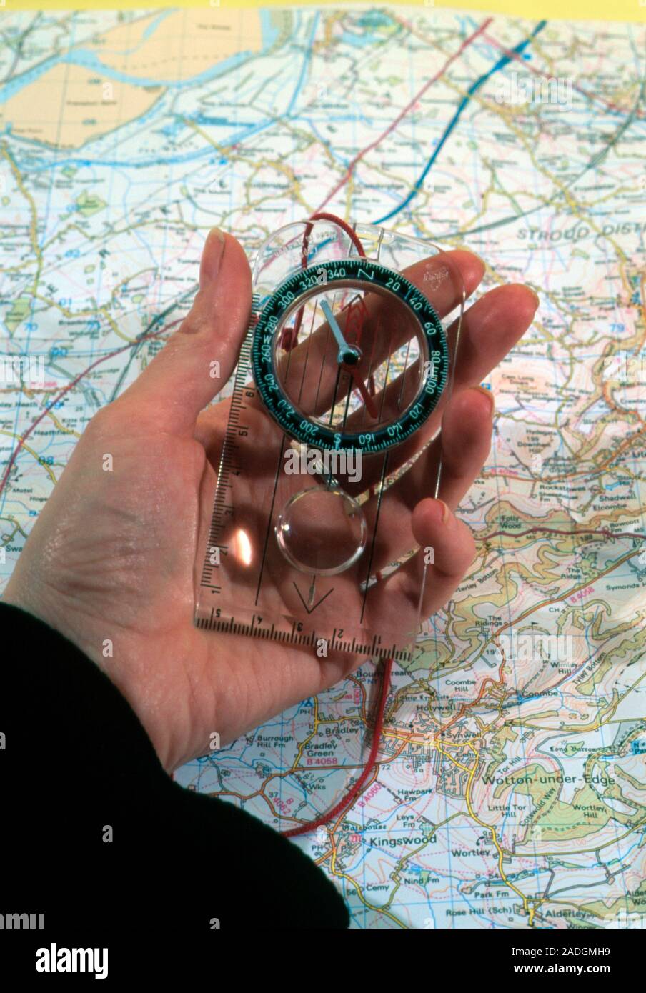 Magnetic compass. Person uses a magnetic compass and an ordnance survey ...