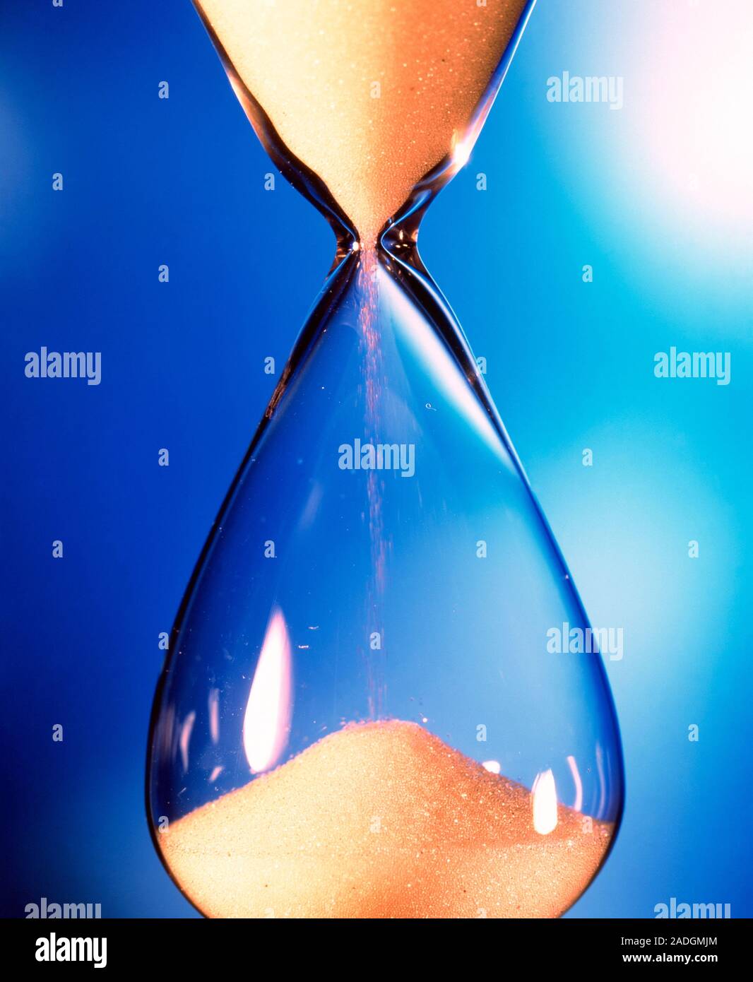 Hourglass. Grains of sand fall from the upper to the lower glass bulb ...