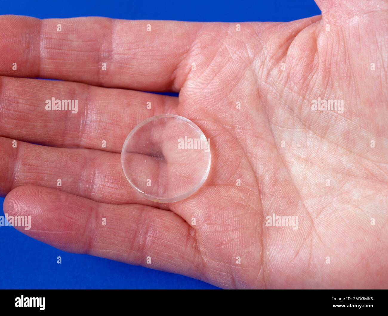 Potassium bromide disc held in a hand. This disc is utilized in ...