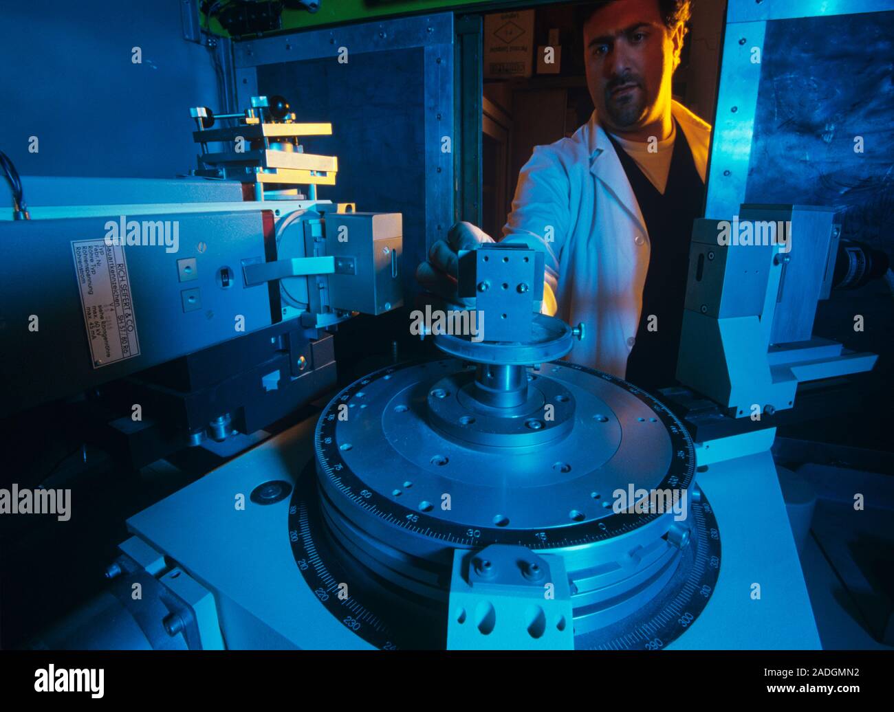 X-ray diffractometer. Researcher placing a sample in an X-ray ...
