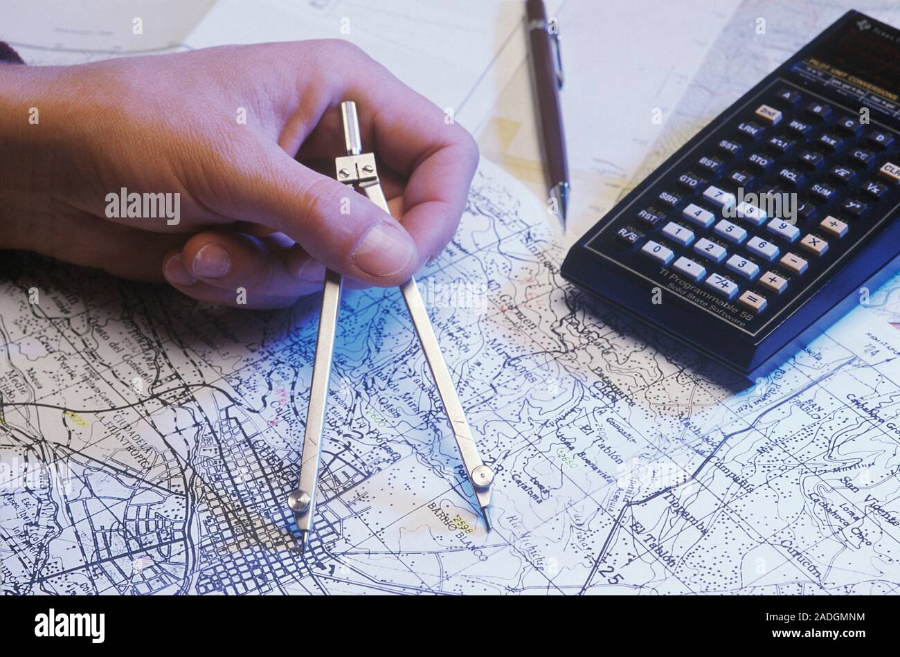 MODEL RELEASED. Navigation. Man calculating distance using a pair of ...