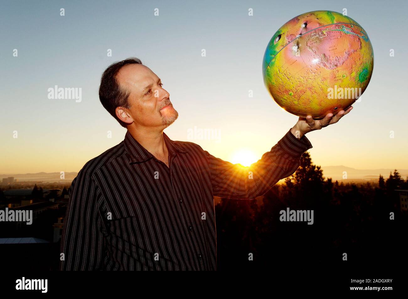 Professor Geoffrey Marcy, astrophysicist, holding a globe of the planet ...