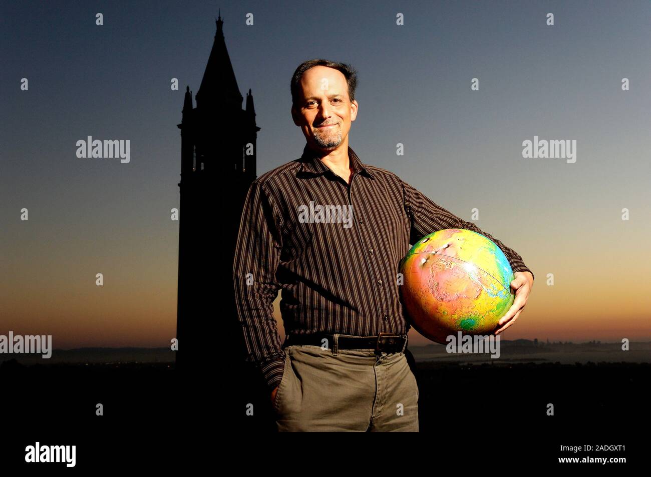 Professor Geoffrey Marcy, astrophysicist, holding a globe of the planet ...