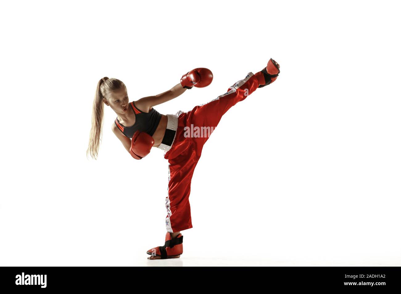 Young female kickboxing fighter training isolated on white background ...