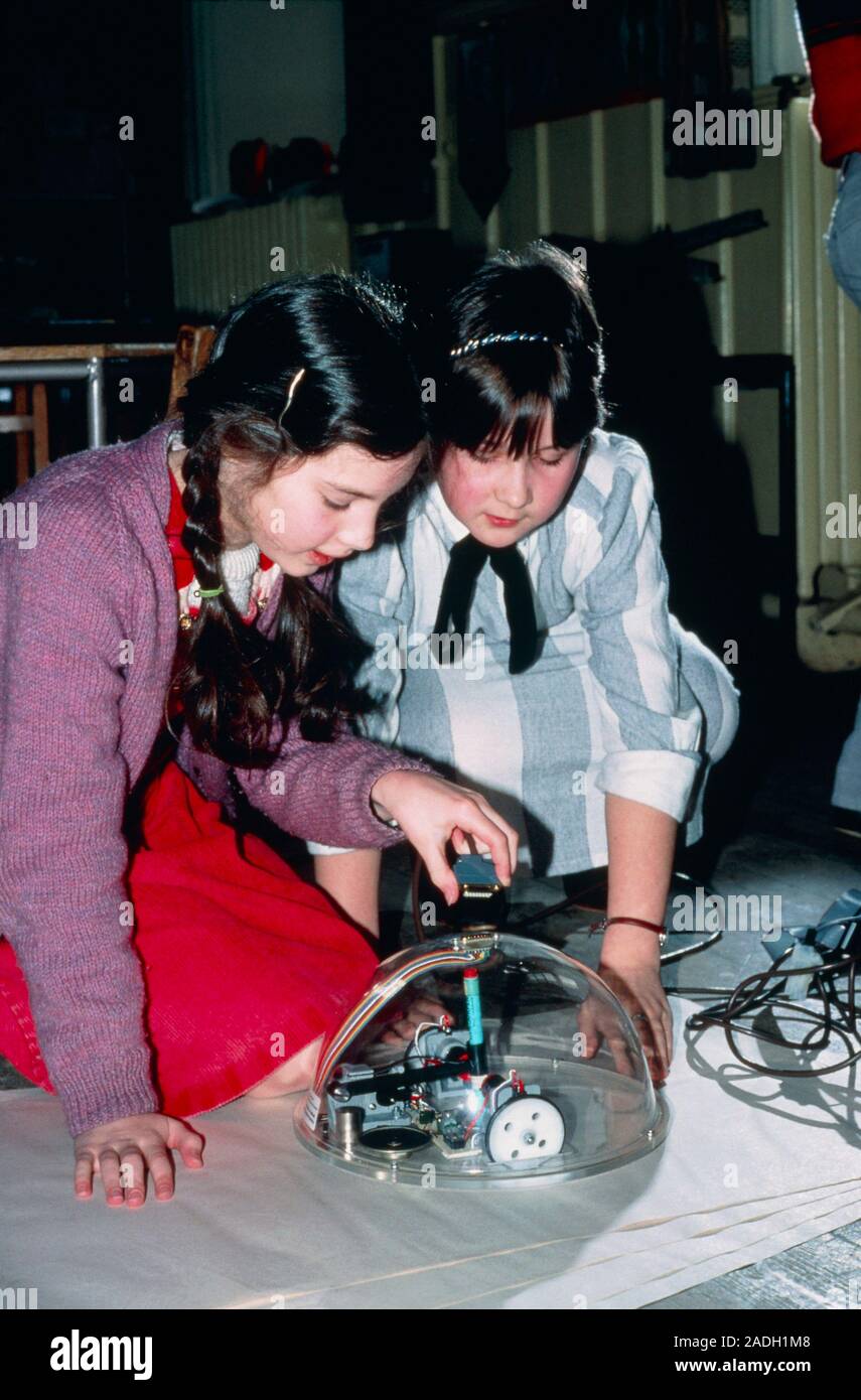 Schoolchildren attaching connecting leads to a Turtle" robot, an ...