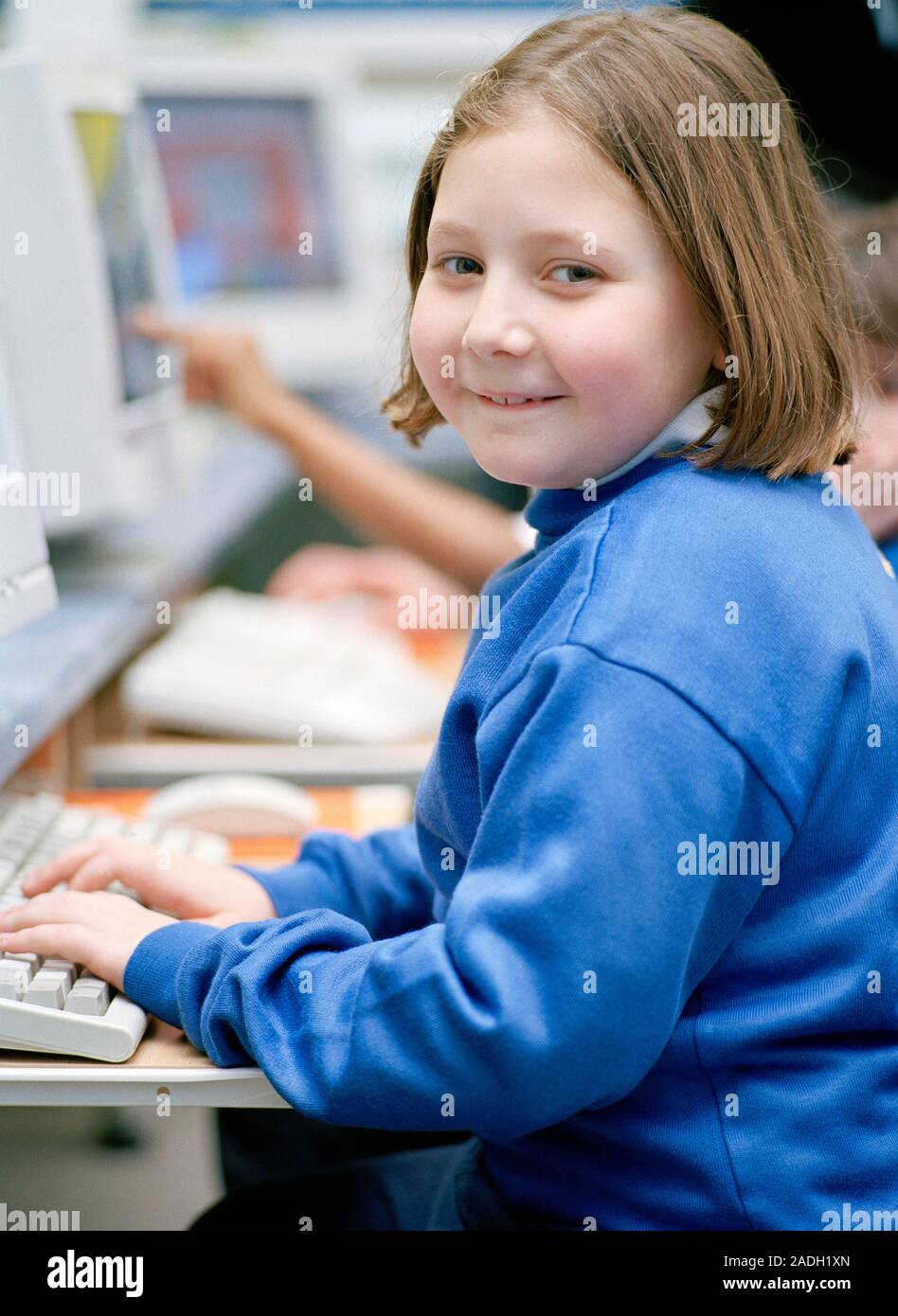 MODEL RELEASED. Computer lesson. Schoolgirl sitting at a computer Stock ...