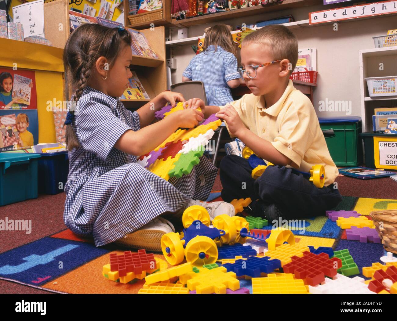 Schoolchildren playing with interlocking plastic shapes. In the ...