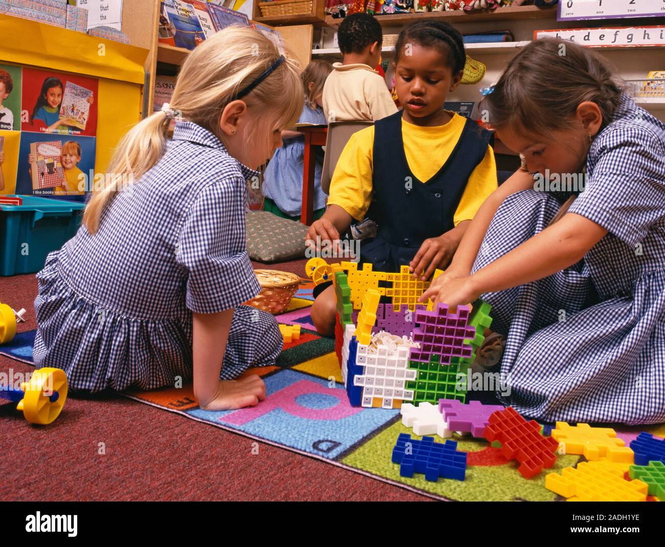 Schoolchildren playing with interlocking plastic shapes. In the ...