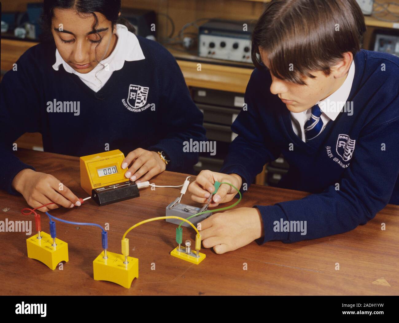 MODEL RELEASED. Pupils setting up a circuit. Two schoolchildren using ...