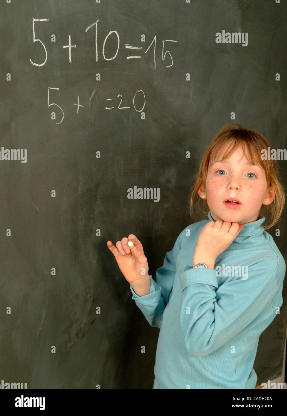 MODEL RELEASED. Numeracy. Pupil at a blackboard completing simple ...