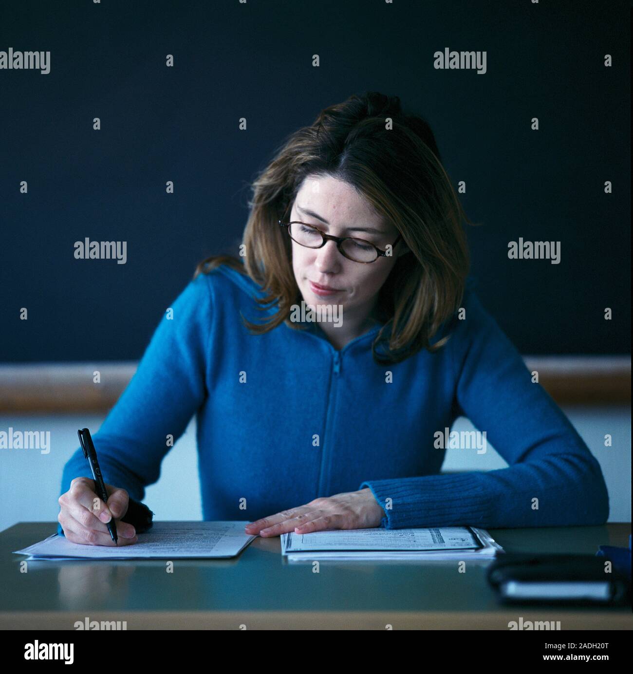 MODEL RELEASED. School teacher marking work at her desk Stock Photo - Alamy