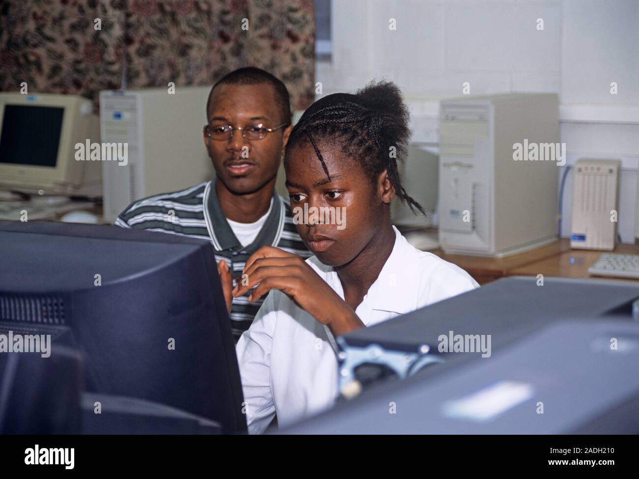 Computer lesson. Teenage girl learning to use a computer. Photographed ...