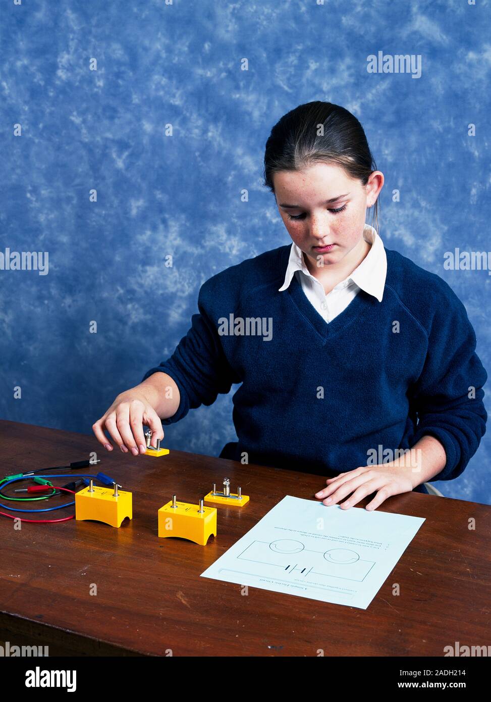Physics experiment. Schoolchild constructing a simple electrical ...
