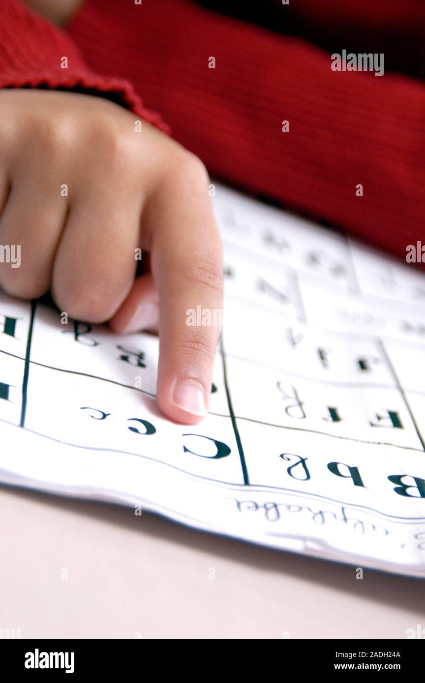 MODEL RELEASED. Reading the alphabet. Six year old girl learning to ...