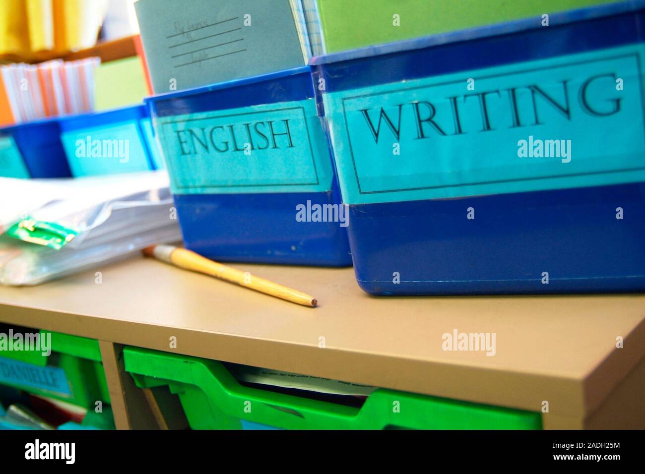 Literacy. Boxes containing English exercise books in a school classroom ...