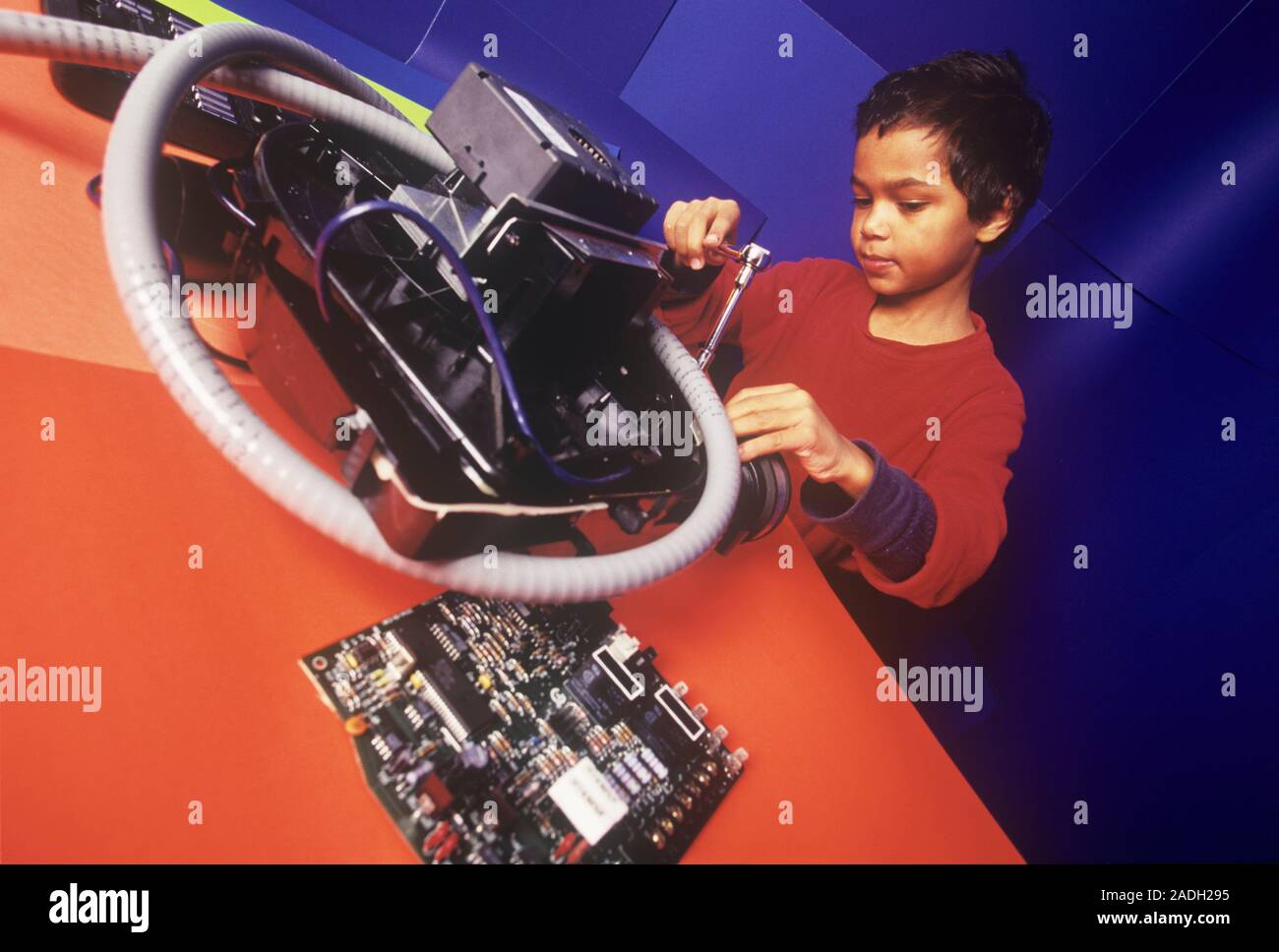 Future engineer. Boy dissembling a motor and fan to learn how it works ...