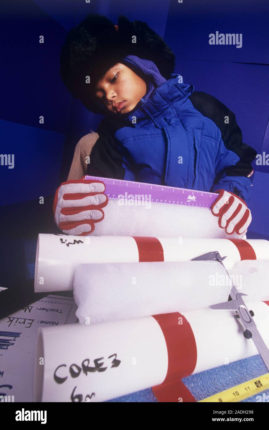 Learning about ice core sampling. Boy measuring the length of ice core ...
