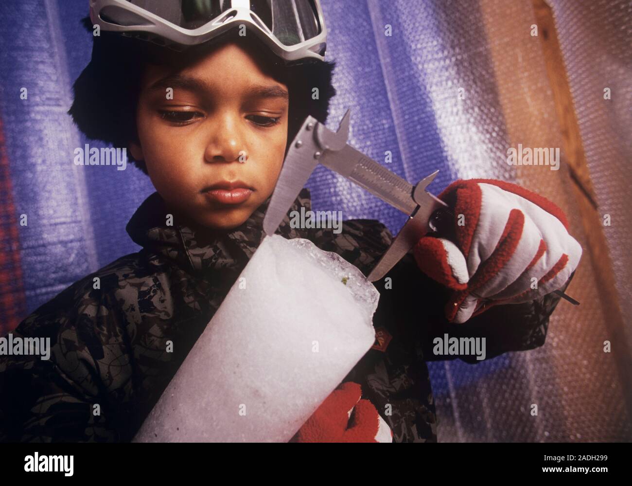 Learning about ice core sampling. Boy measuring the diameter of ice ...