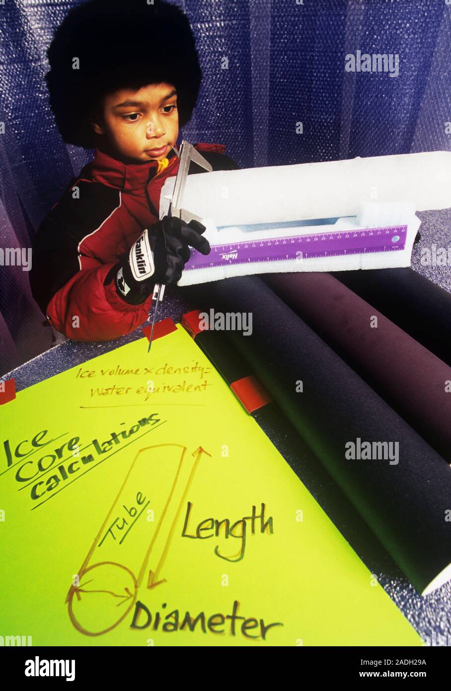Learning about ice core sampling. Boy measuring the length and diameter ...