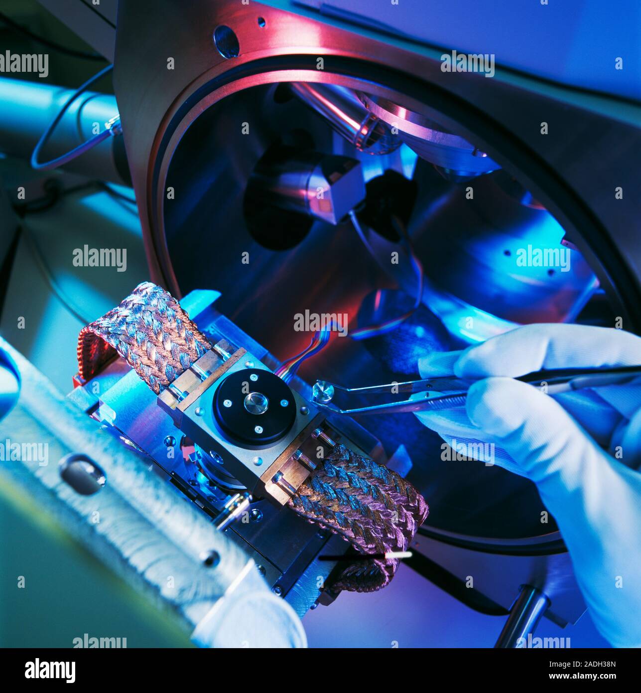 Scanning electron microscope. Scientist placing a sample (in forceps ...