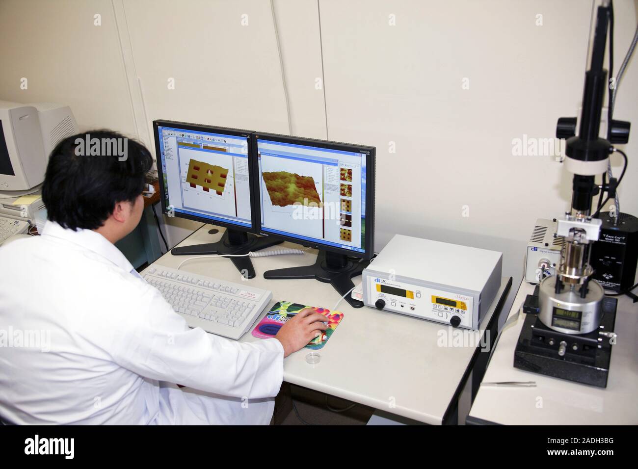Atomic force microscopy. Researcher using a computer to analyse images of a sample scanned by an ...