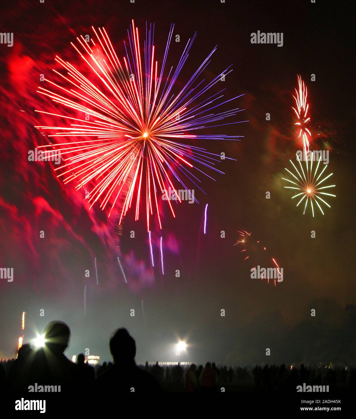 Fireworks display with a silhouetted crowd of spectators, time-exposure ...