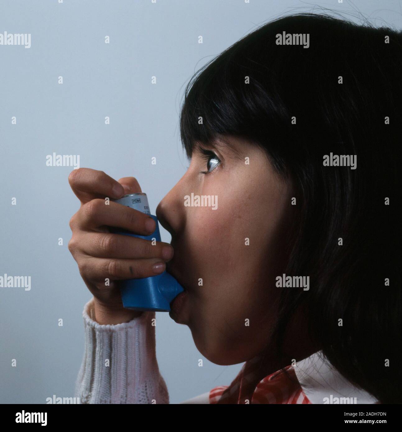 Six year old child using a pressurized aerosol Brycanyl inhaler to ...