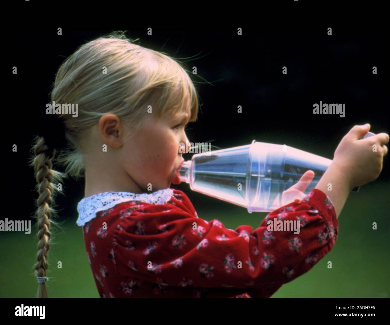Volumatic asthma inhaler. A girl with asthma uses an inhaler with a ...