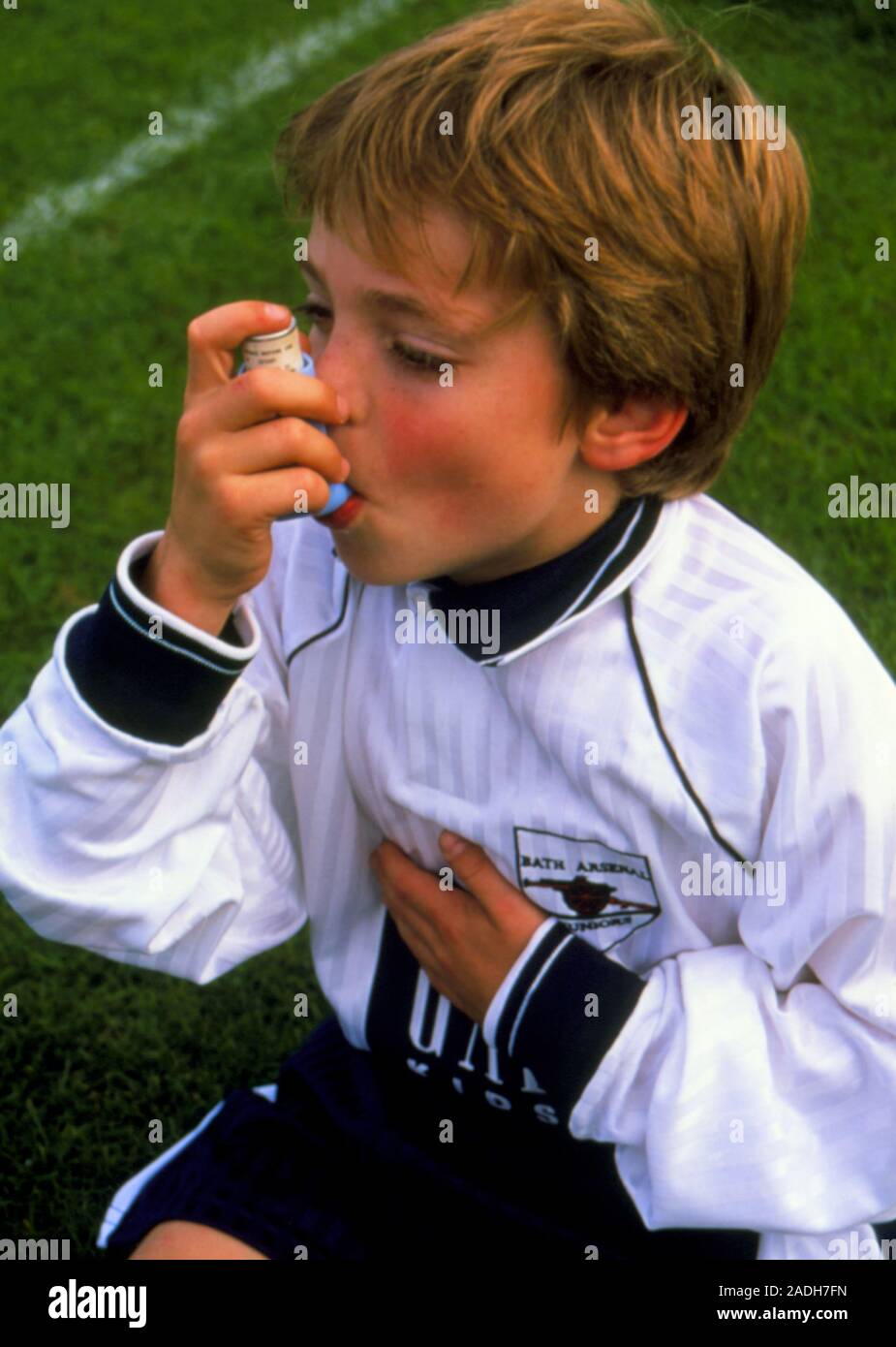 Asthma inhaler. Young boy uses an aerosol inhaler to treat an asthma ...