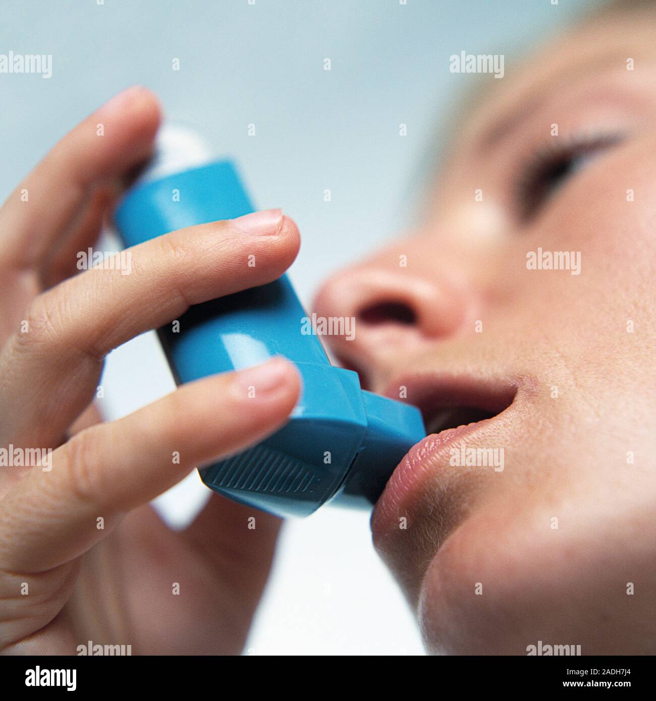 Asthmatic woman using her inhaler. Asthma is a condition in which the ...