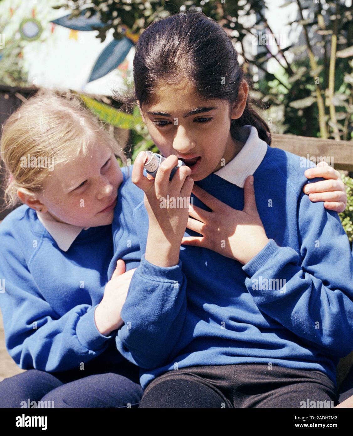 Asthmatic girl being comforted by a friend, while using her inhaler ...