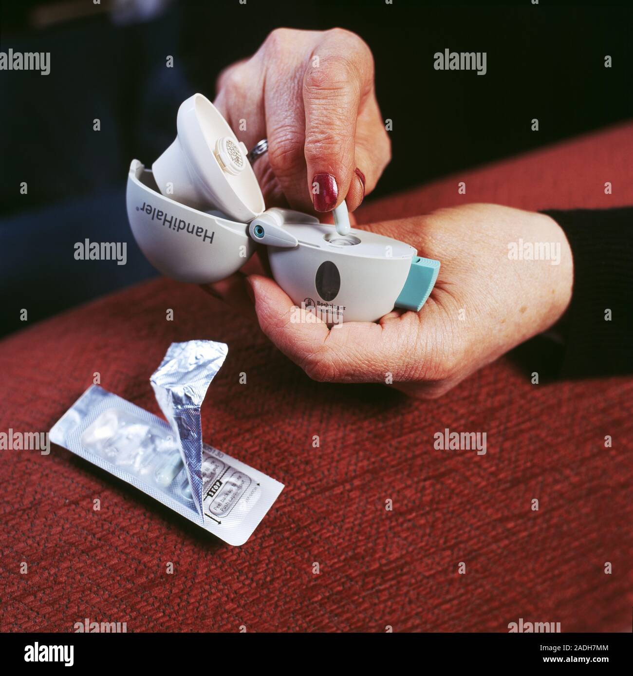 Loading an inhaler. Woman loading a drug capsule into an inhaler Stock ...