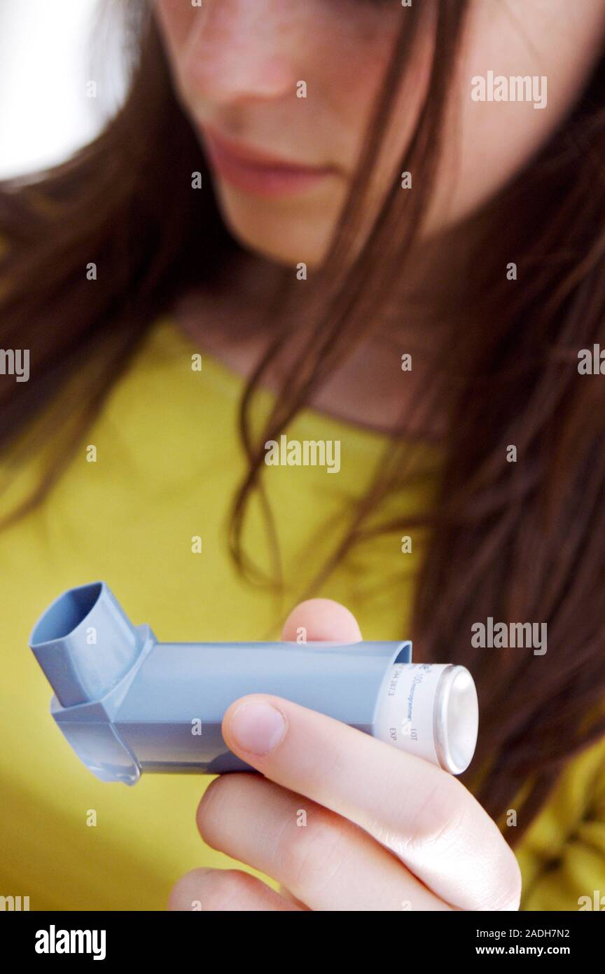 Asthma inhaler. Young girl holding an aerosol inhaler for the treatment ...