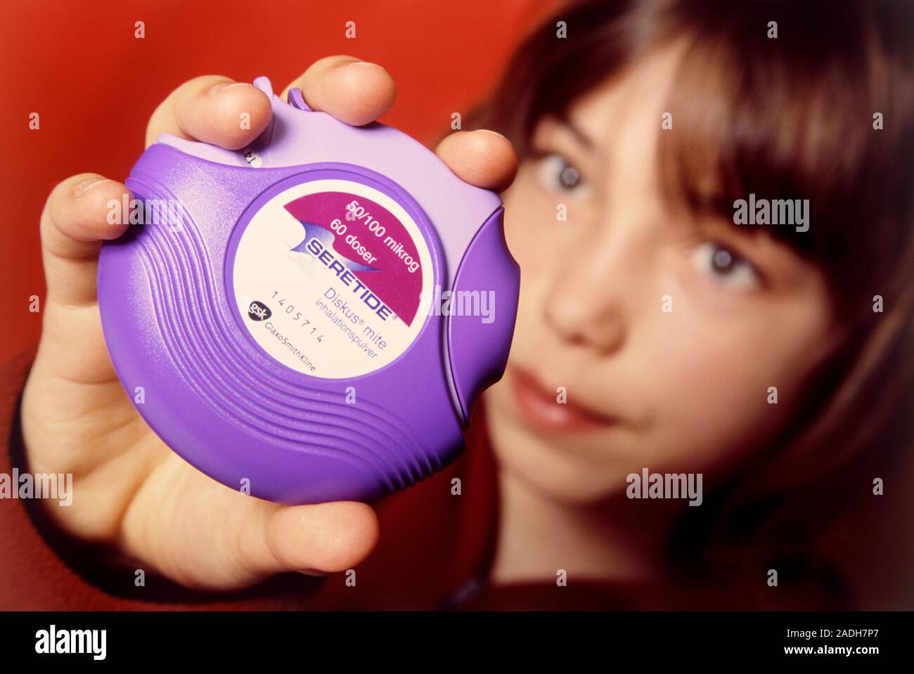 Asthma inhaler. Young girl holding a Seretide inhaler used to treat ...