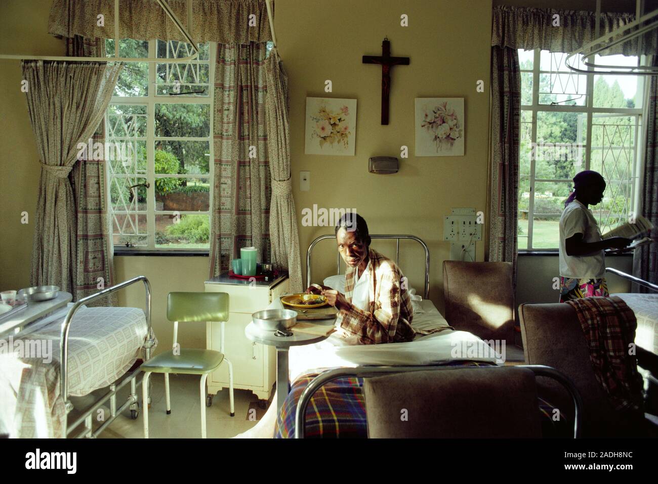 AIDS clinic. Patient eating a meal at a clinic for people with AIDS ...
