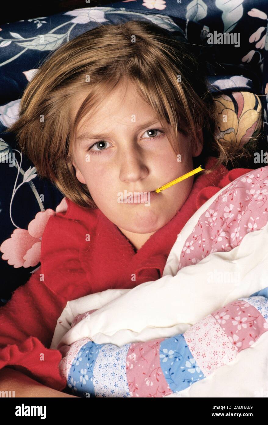 Common cold. Teenage girl suffering from a common cold checks her ...