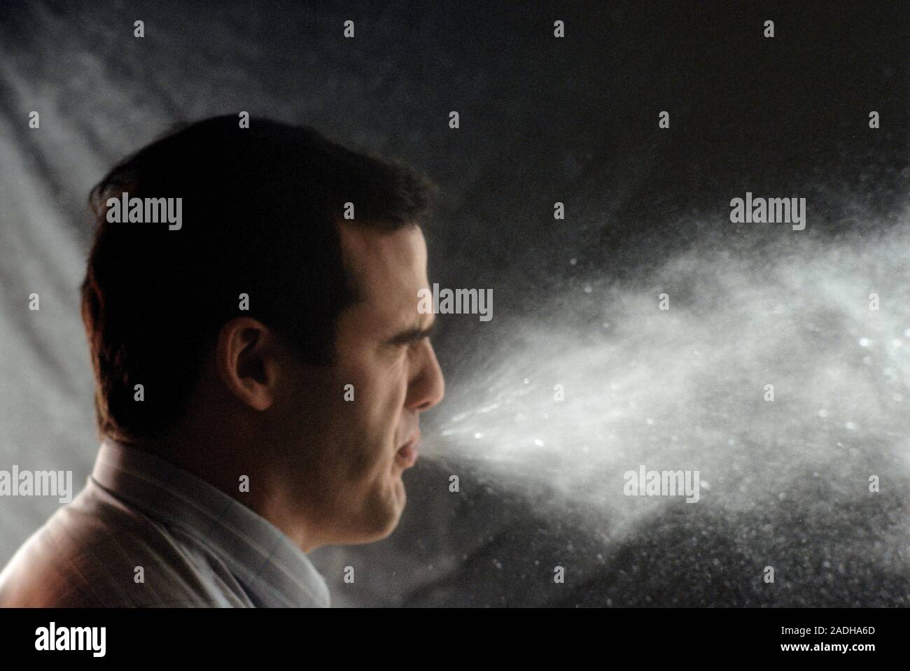Sneeze. High-speed photograph of a jet of droplets erupting from a man ...