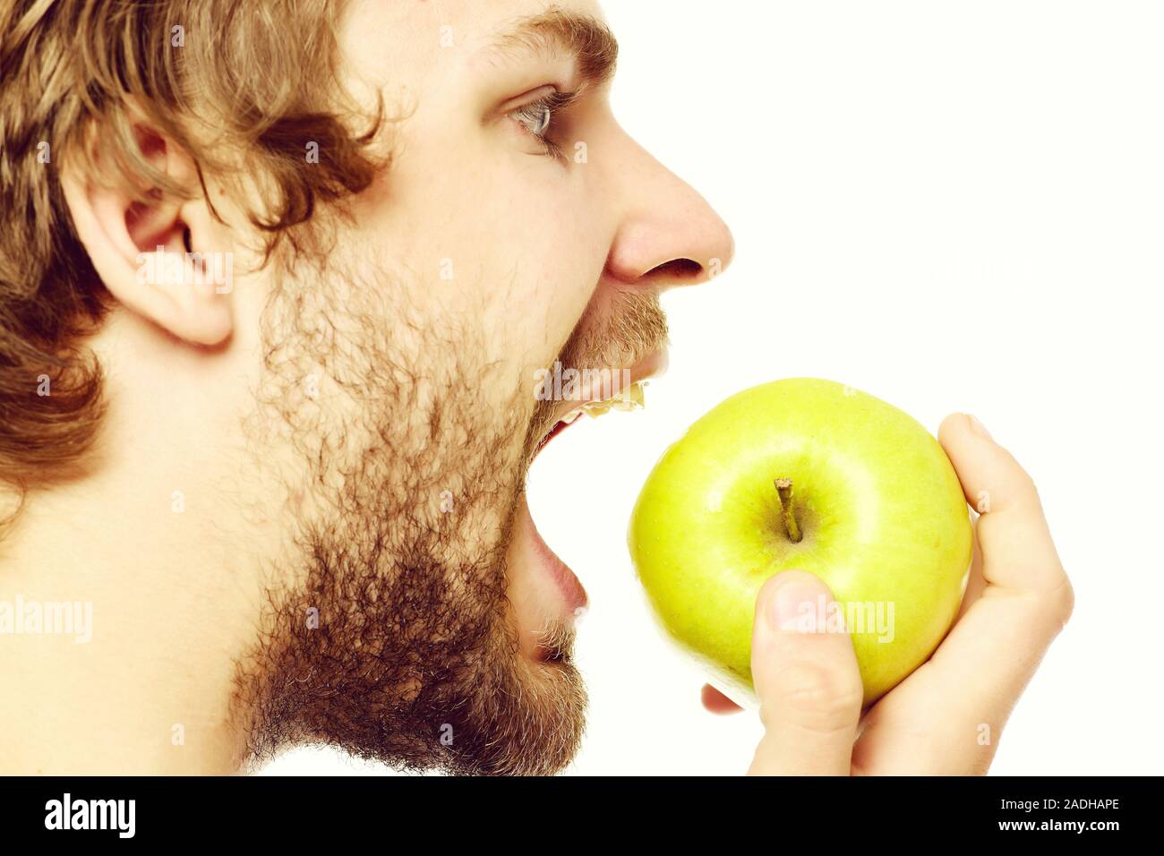 Apple and man. Young caucasian guy biting big green apple in close up ...