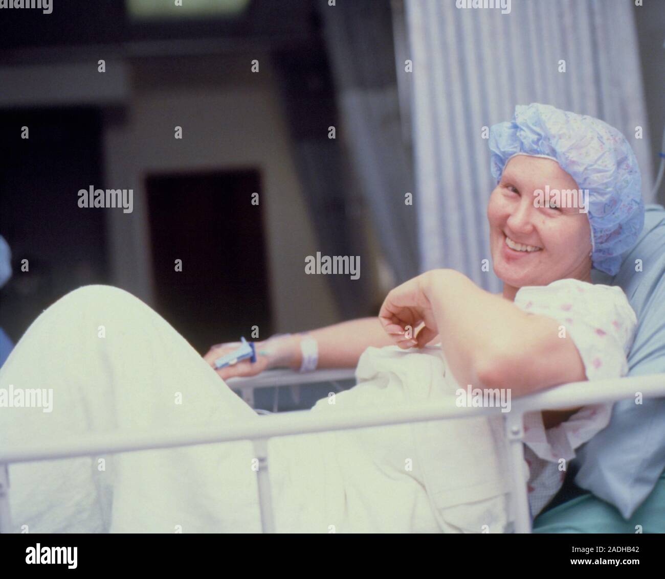 Cancer patient. Smiling female cancer patient sitting up in a hospital ...