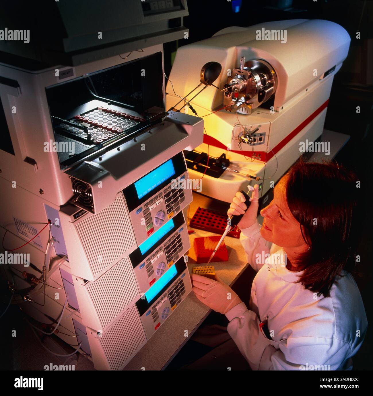 Cancer drug research. Female researcher using a pipette to place ...