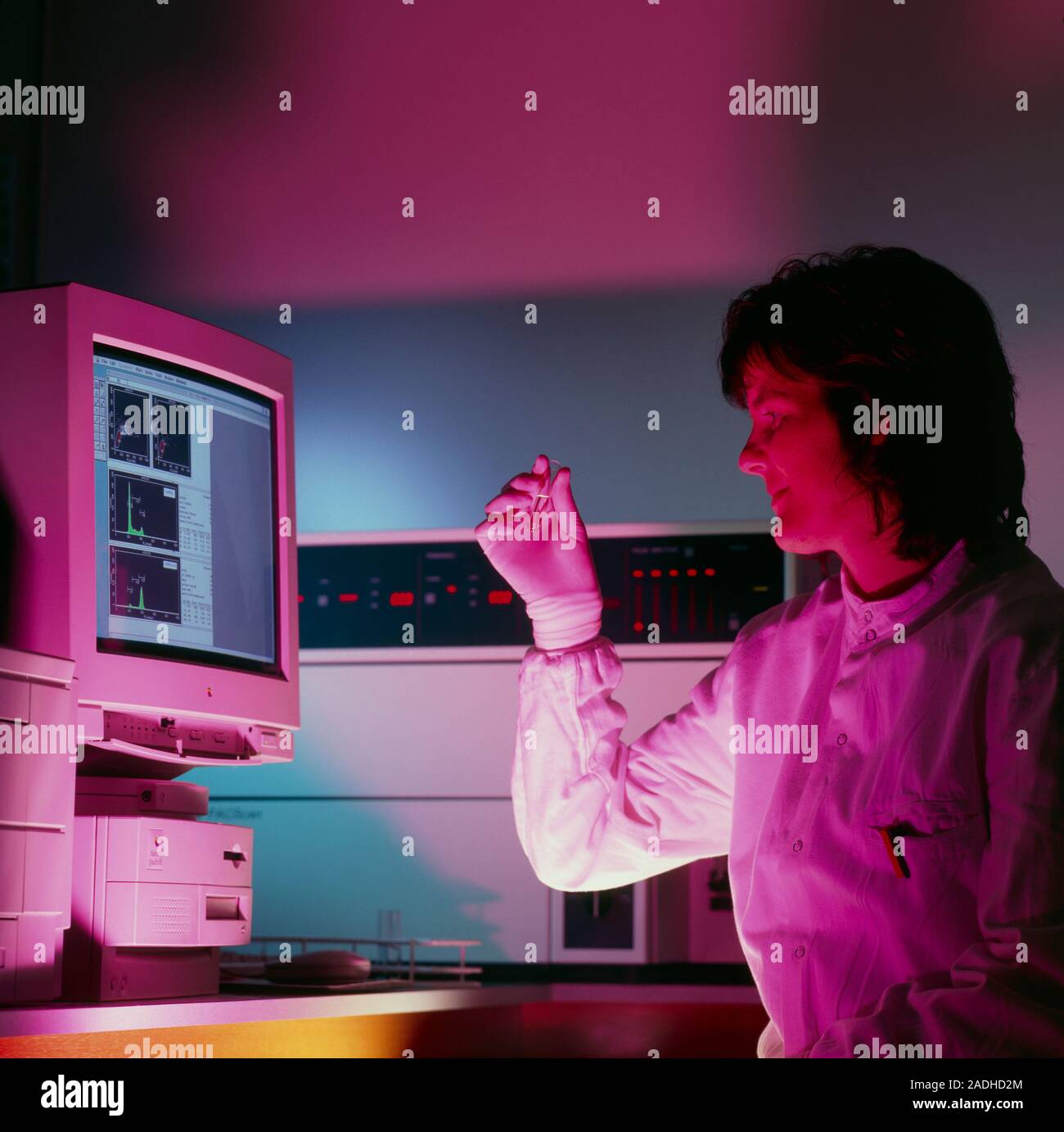 Cancer drug research. Female researcher holding a sample tube in front ...