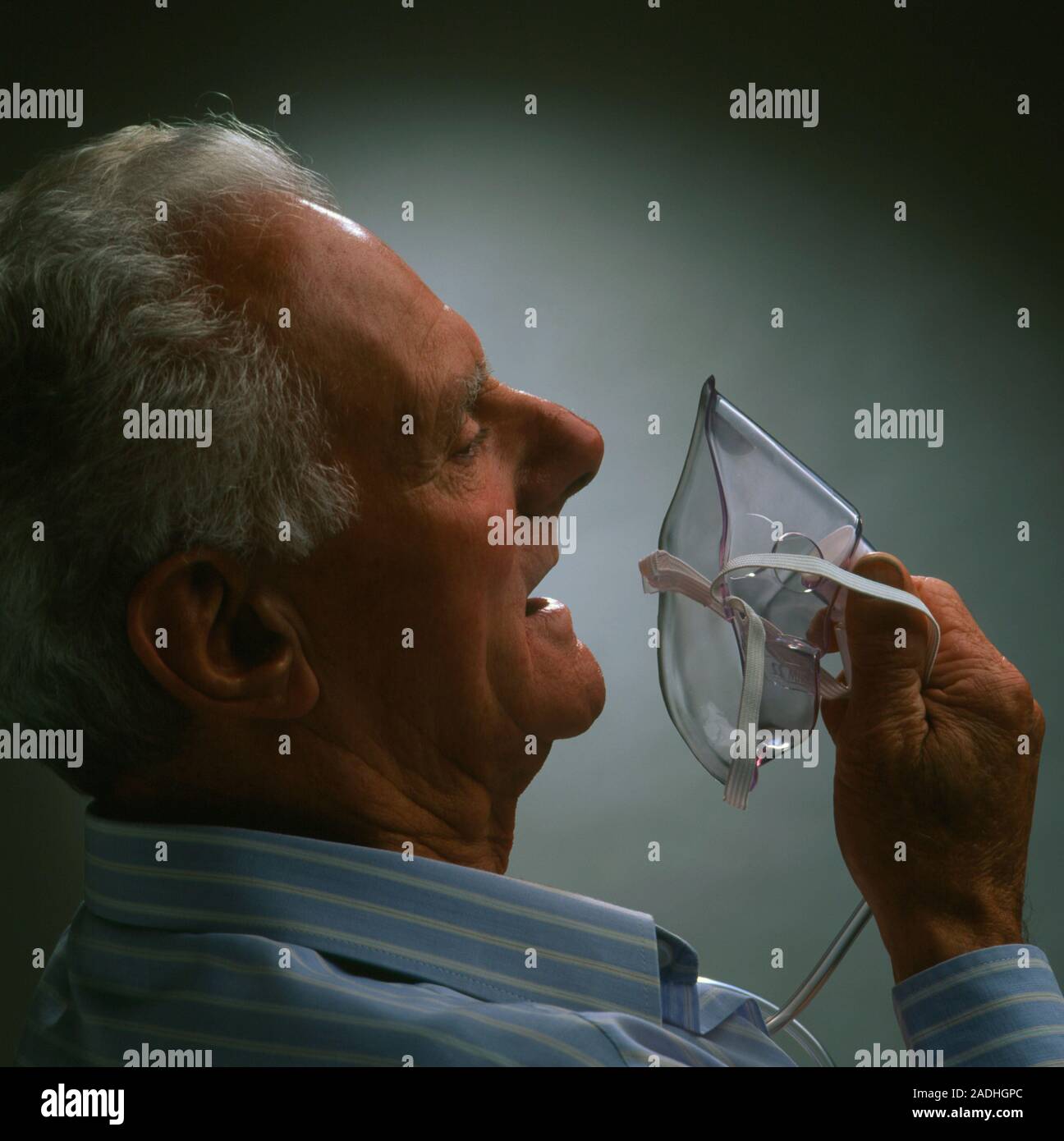 Heart attack oxygen therapy. View of an elderly man holding an oxygen ...