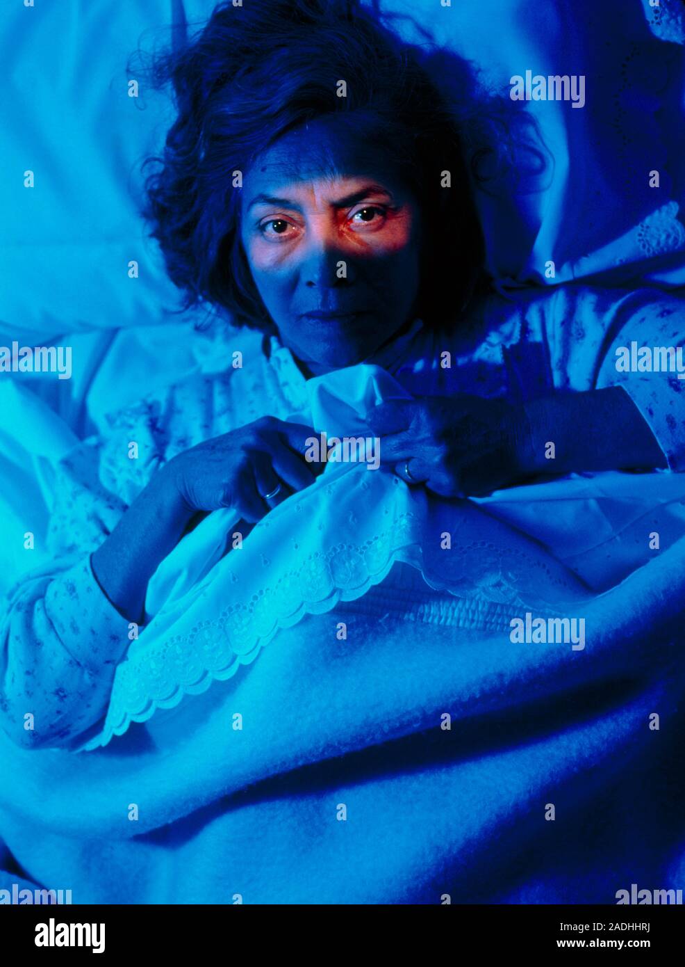 Insomnia. Restless woman in bed trying to sleep, a beam of light ...