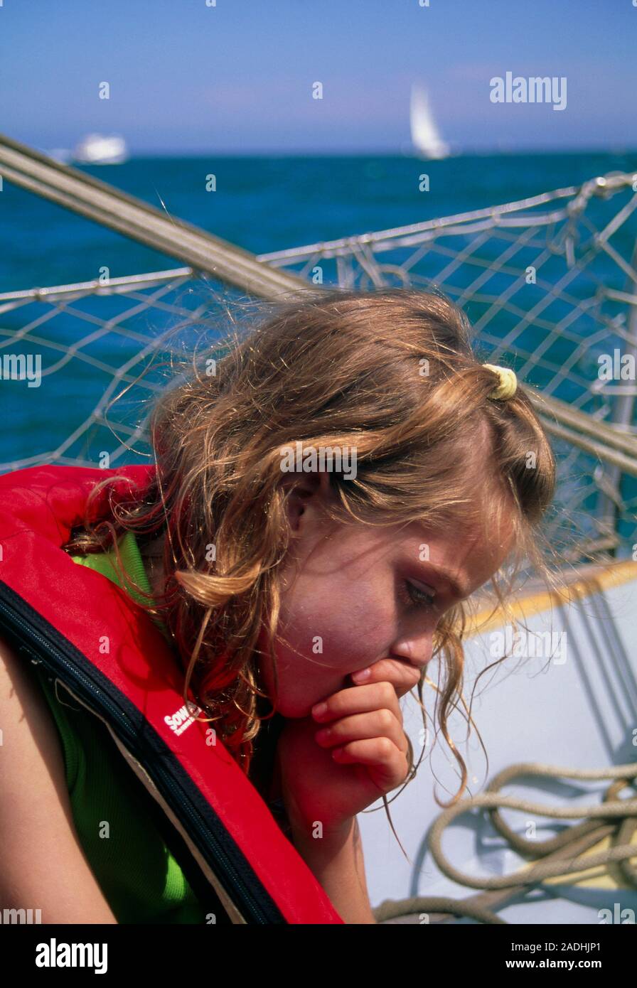 Seasickness. Young girl on a boat at sea suffering from seasickness ...