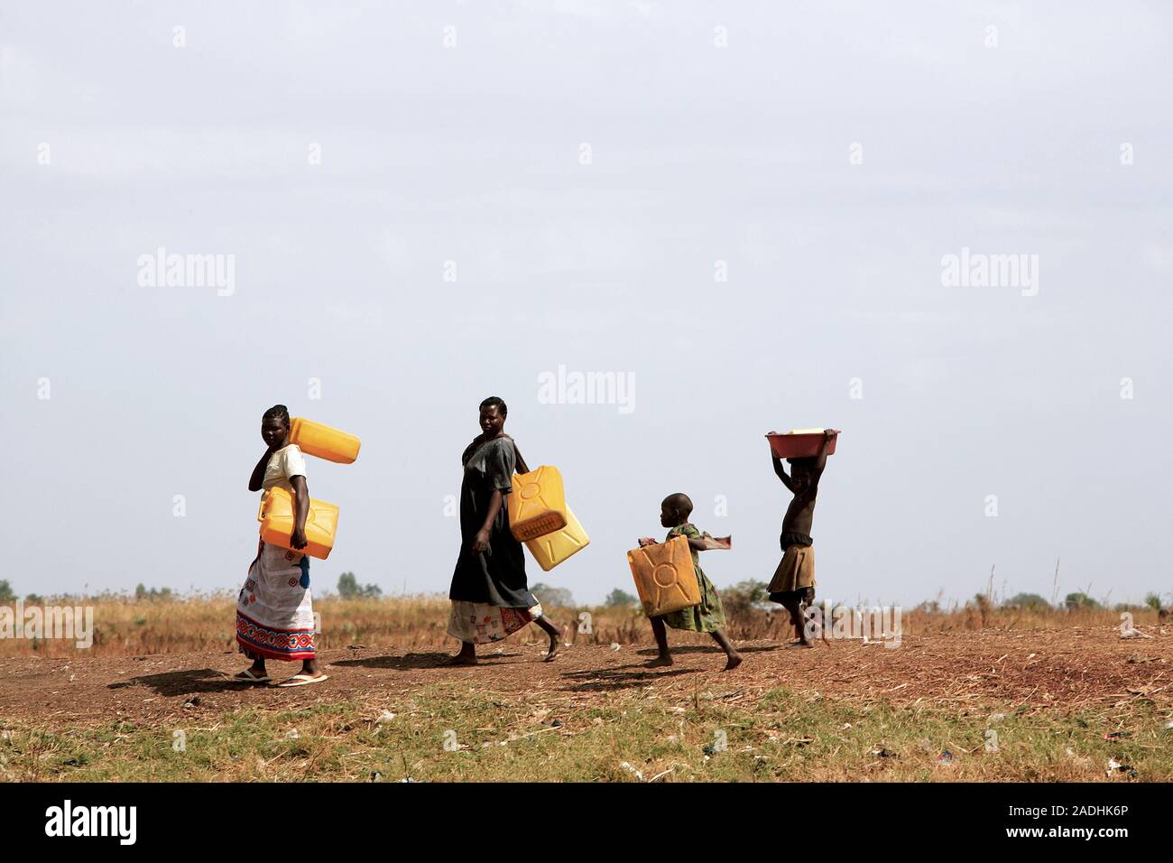 Refugees fetching water. Women and children carrying empty water ...