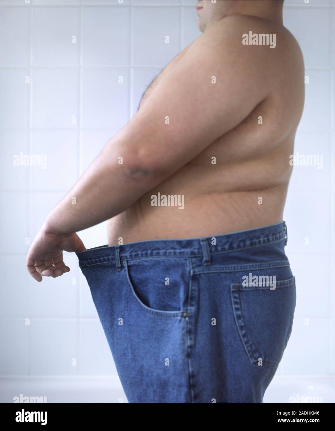 Obesity. Overweight man checking the fit of his jeans Stock Photo - Alamy