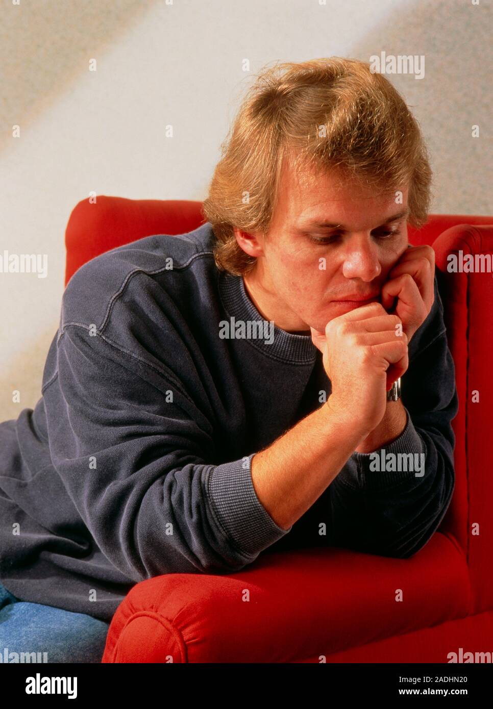 MODEL RELEASED. Depression. A young man leans on the side of his ...