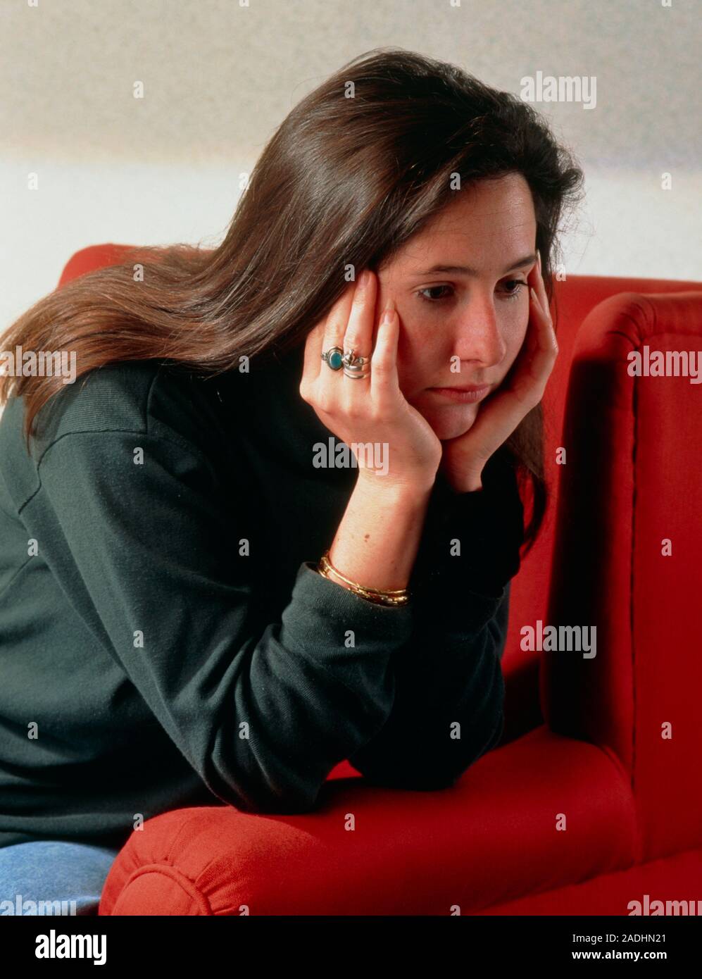 MODEL RELEASED. Depression. A young woman leans on the side of her ...